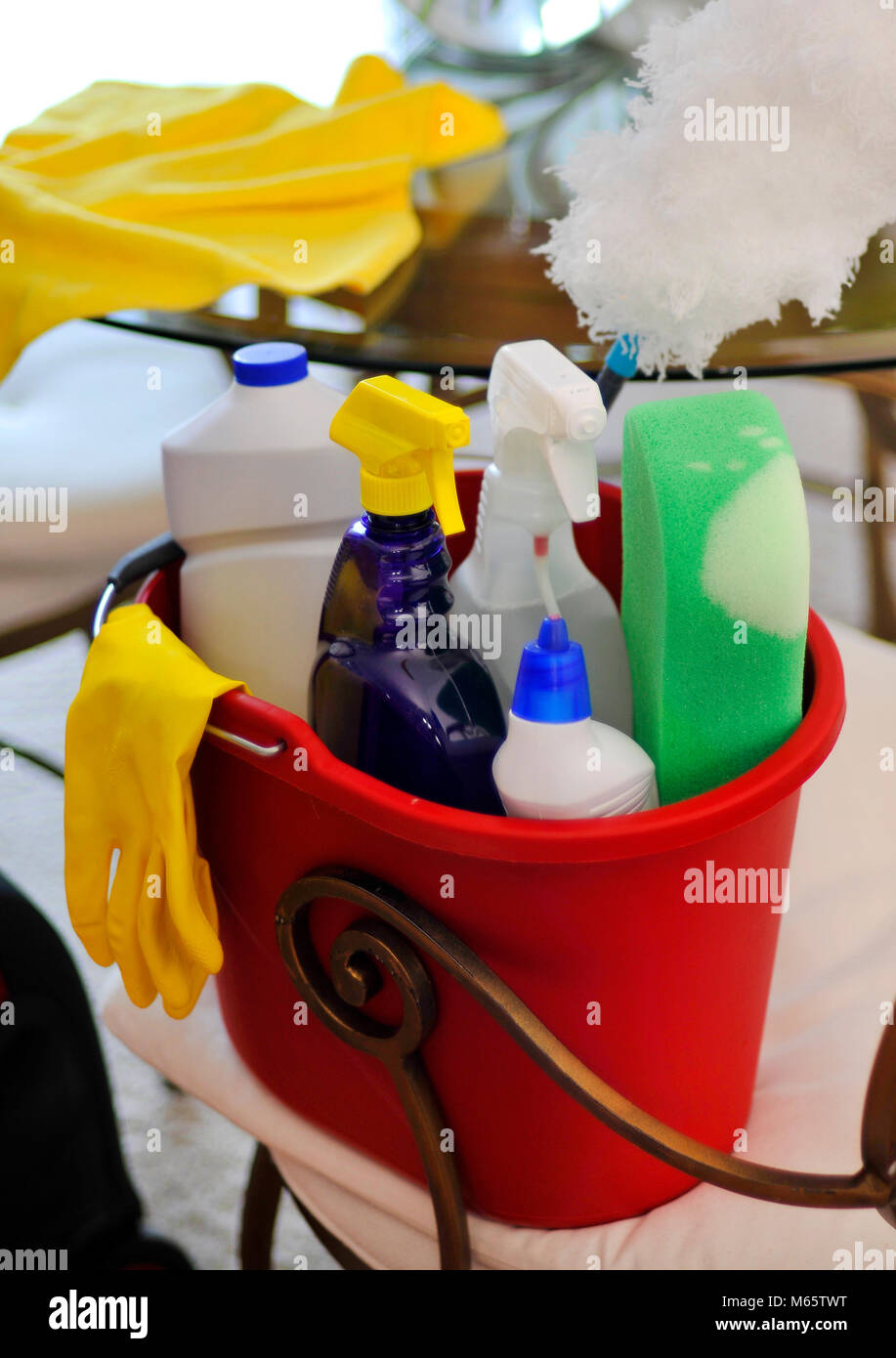 Bucket with cleaning supplies and vacuum cleaner near table Stock Photo ...