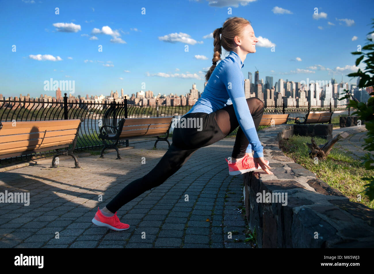 Sport and fitness. Woman stretching before run in park with view of ...