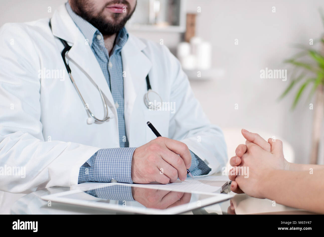 Doctor is writing prescription to patient Stock Photo - Alamy