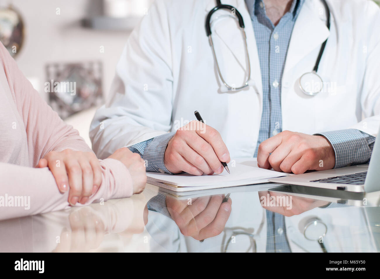 Doctor is writing prescription to patient Stock Photo - Alamy