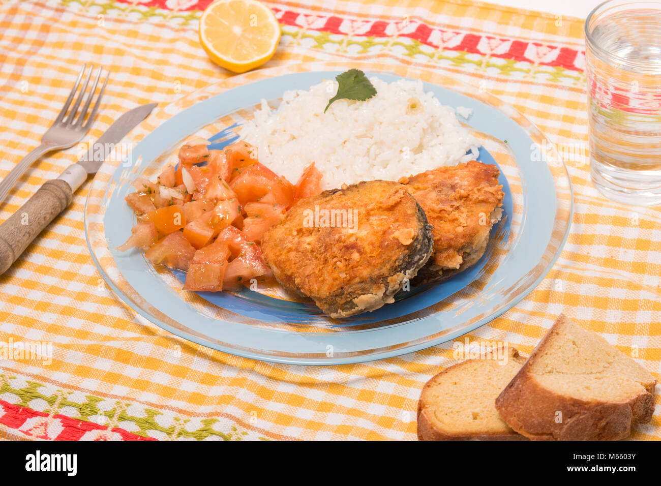 Fried hake fish with rice and tomato salad Stock Photo - Alamy