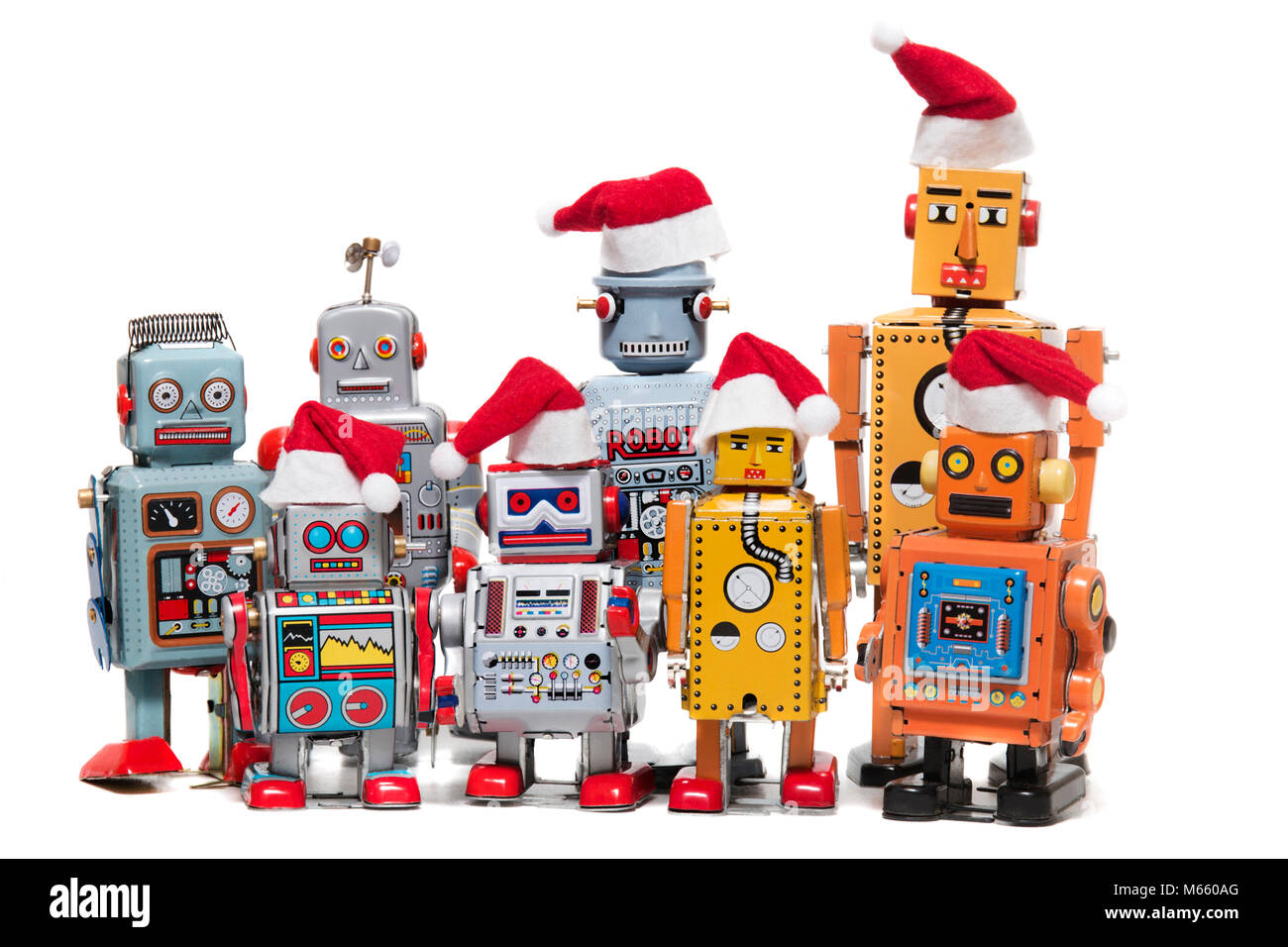 Vintage tin robot toys with xmas hats isolated on a white background ...