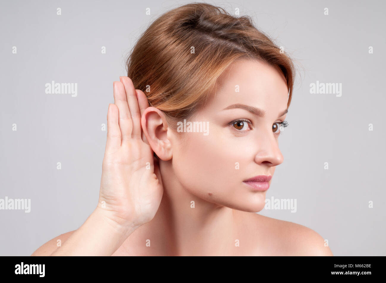 Beautiful woman hold hand near her ear and listening carefully Stock ...