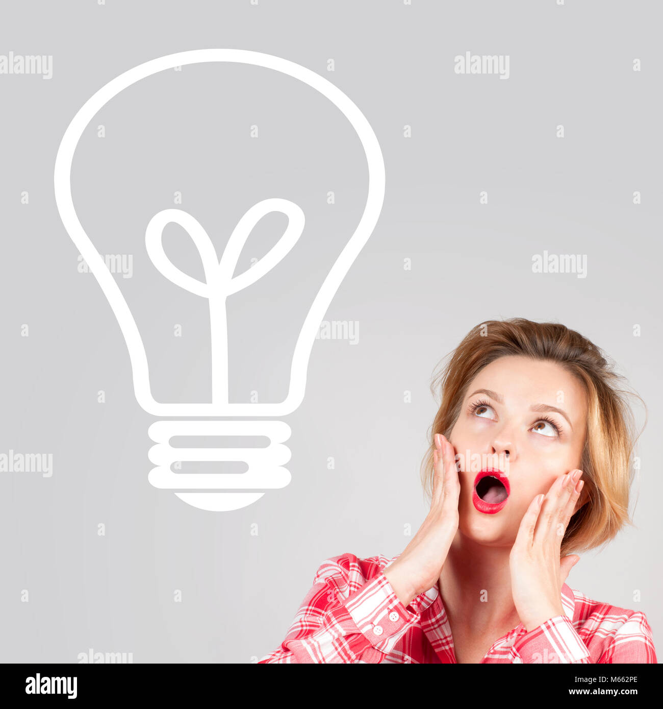 Beautiful business woman has an idea with a light bulb over her head ...