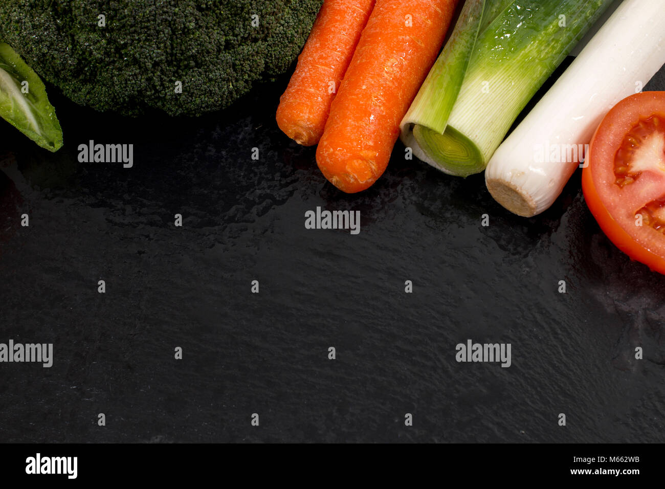 Mixed wet vegetables on top of a black slab of schist Stock Photo - Alamy