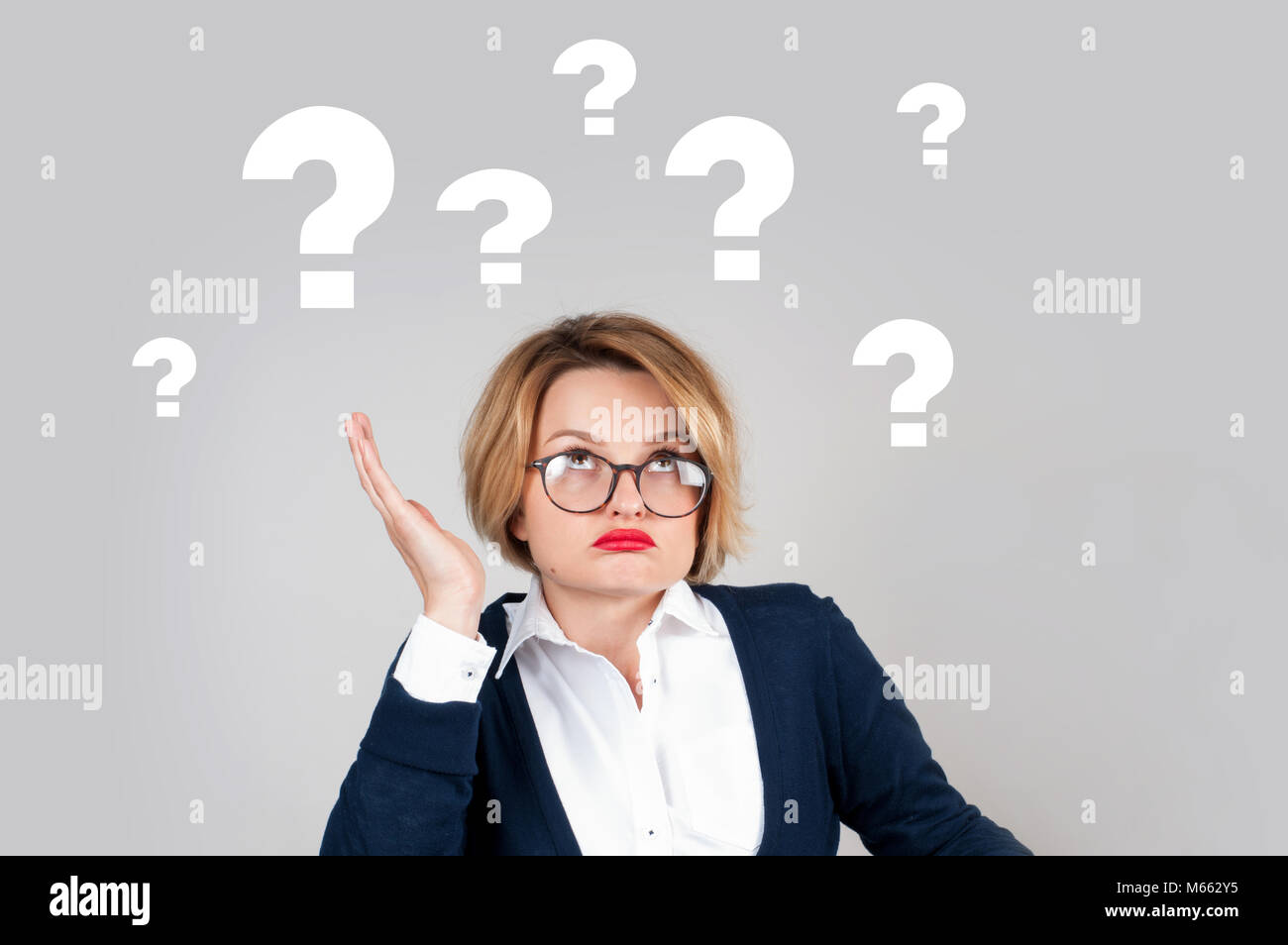 Thinking woman with questioning expression and question marks above her ...