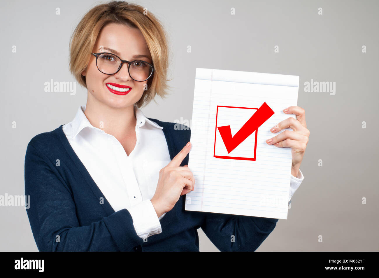 Beautiful business woman holding blank paper with check mark or ...