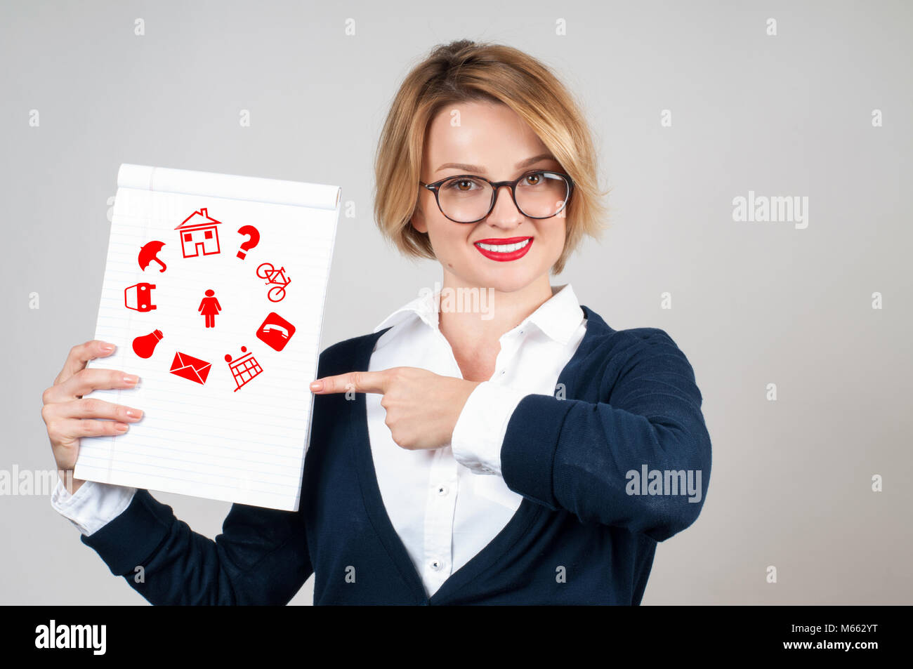 Beautiful young woman, pointing finger at multimedia icons on white ...