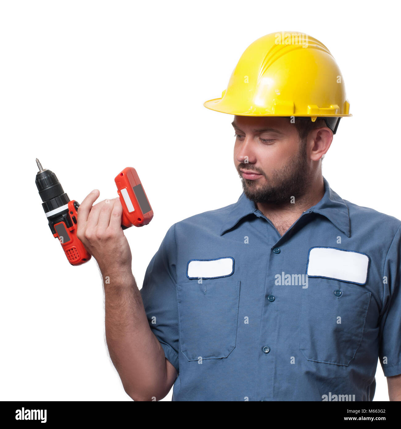 Contractor. Man in uniform and yellow helmet with drill Stock Photo - Alamy