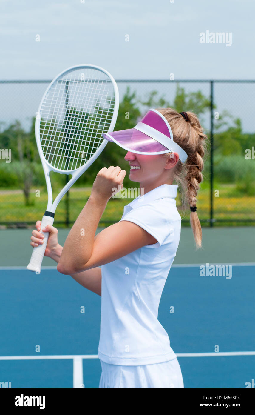 Tennis player celebrating after winning a tennis match. Young woman is ...