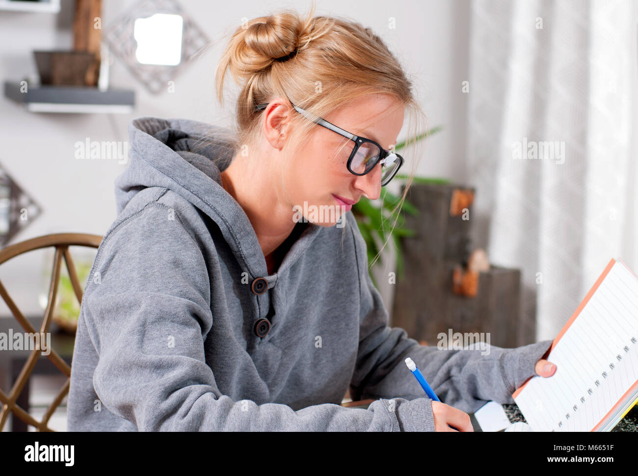 Pretty female student with books studying at home. College girl doing ...
