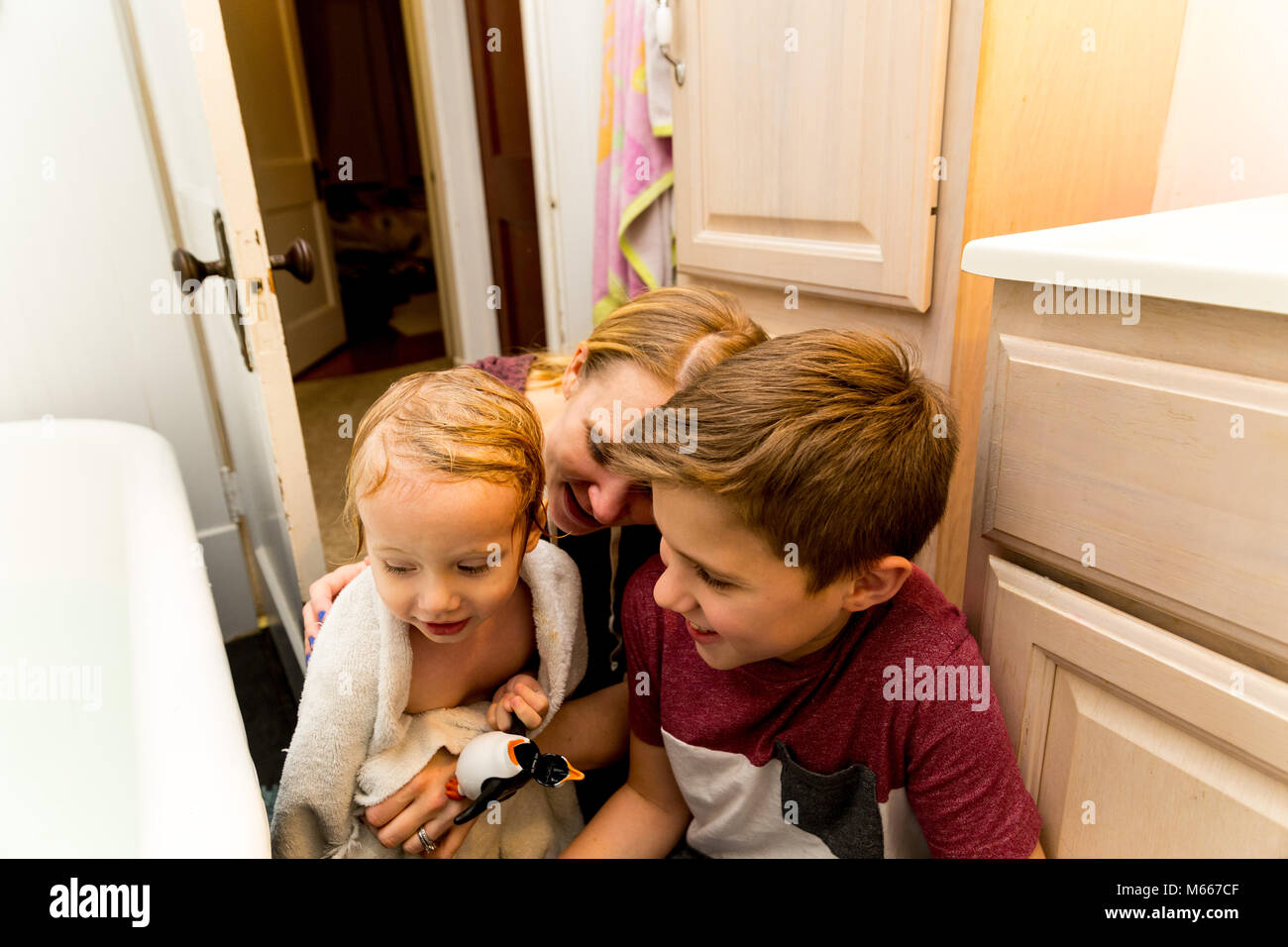 A Caucasian Mom And A Little Boy Help Dry Off A Toddler Child After His ...
