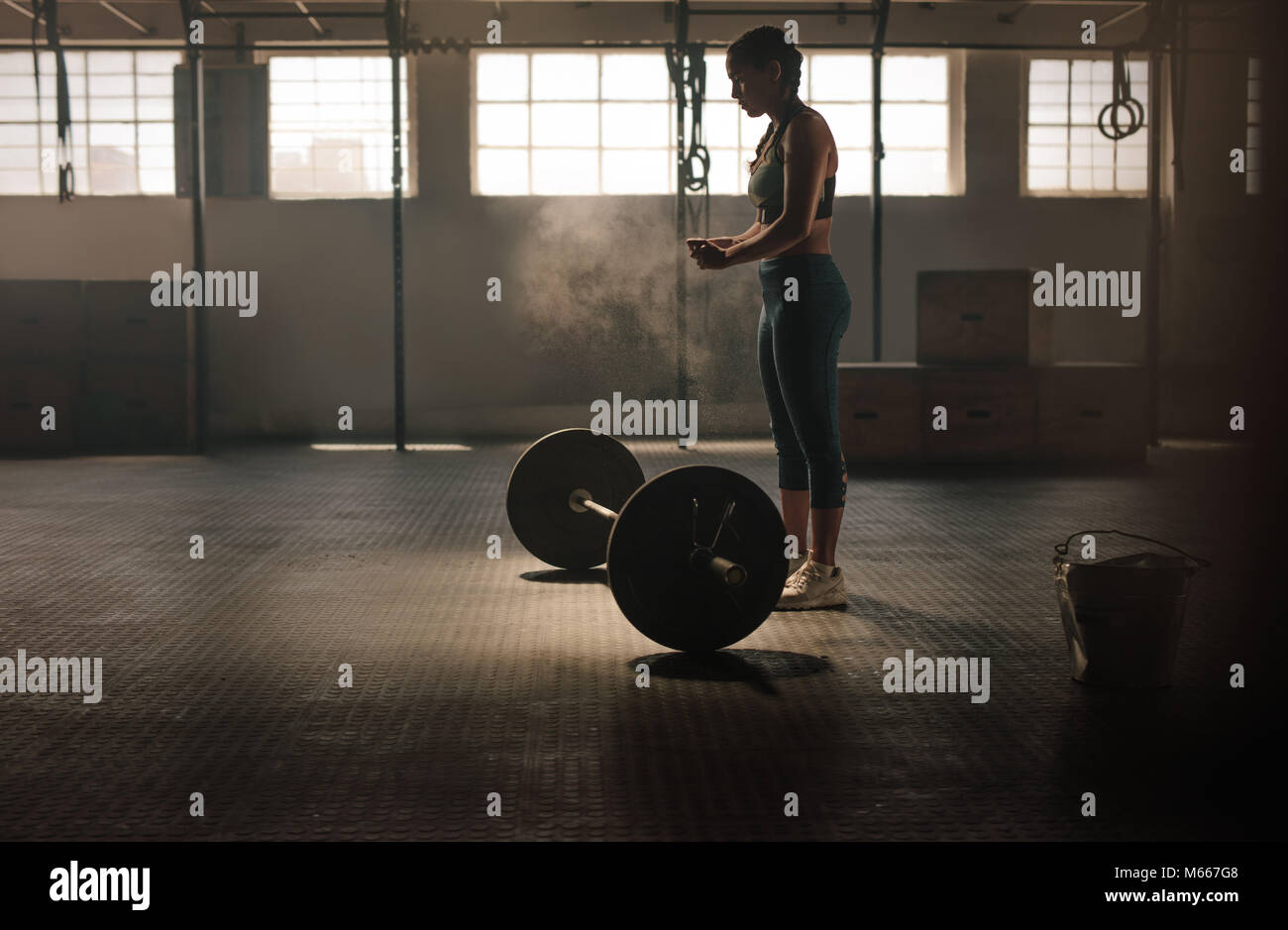 Strong young woman about to lift heavy weights at gym. fitness female ...