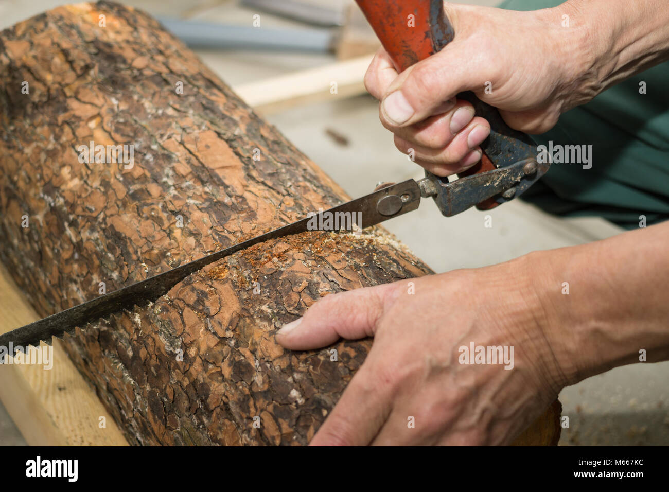 Carpenter saws off with a hacksaw the wood piece for birdhouse Stock ...