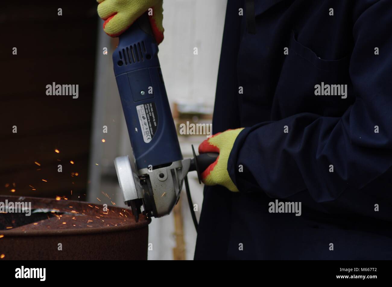Young Man with a Power Tool Undertaking DIY Home Improvement Work in a ...