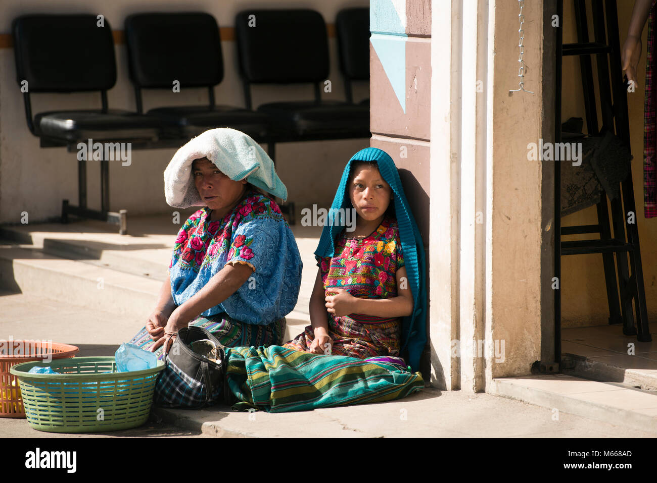 An indigenous K'iche' (Quiché) Maya woman and her daughter selling food ...