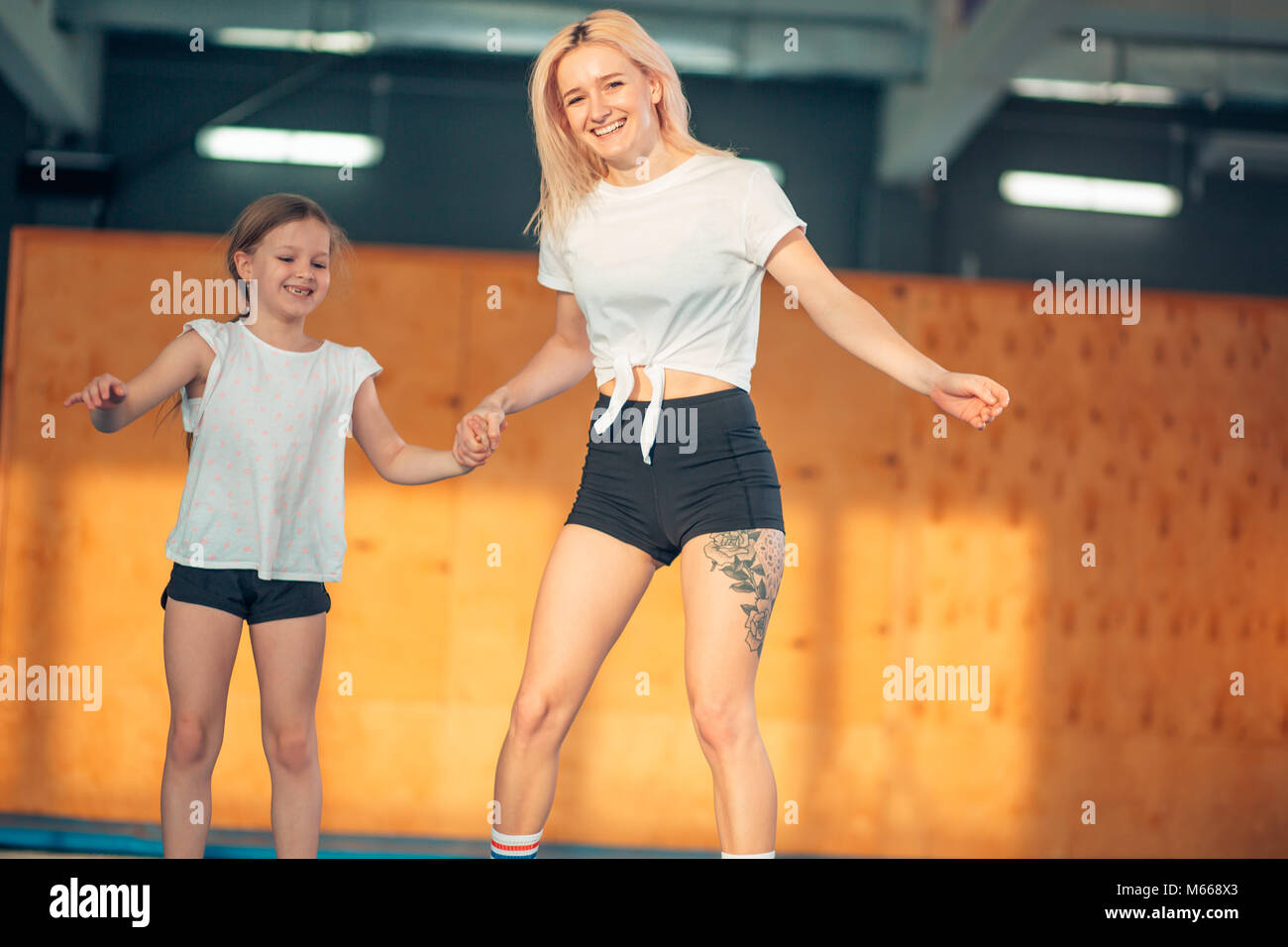 mother and daughter jumping on trampoline and doing split Stock Photo ...