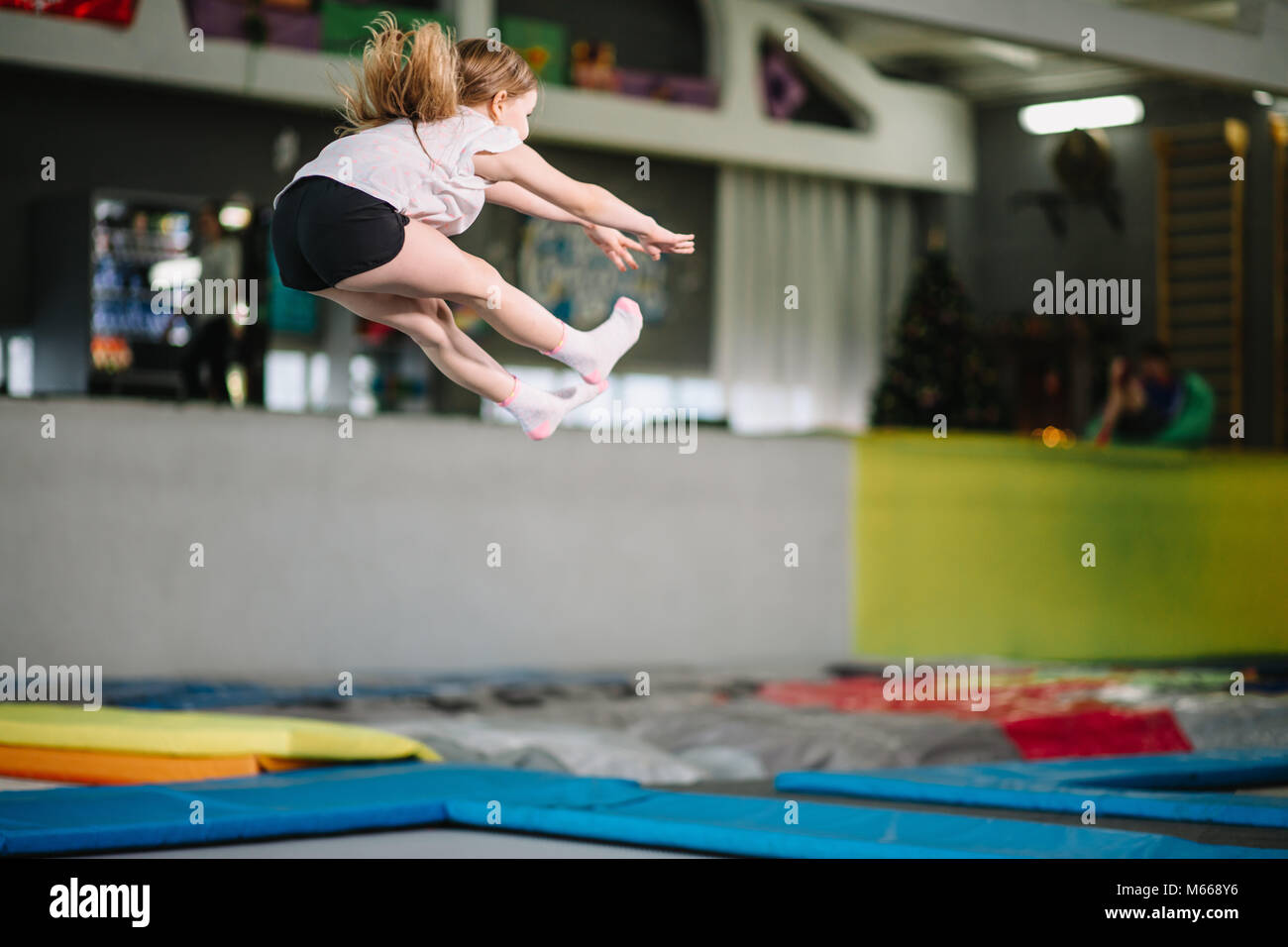 Girl jumping high in striped tights on trampoline Stock Photo - Alamy