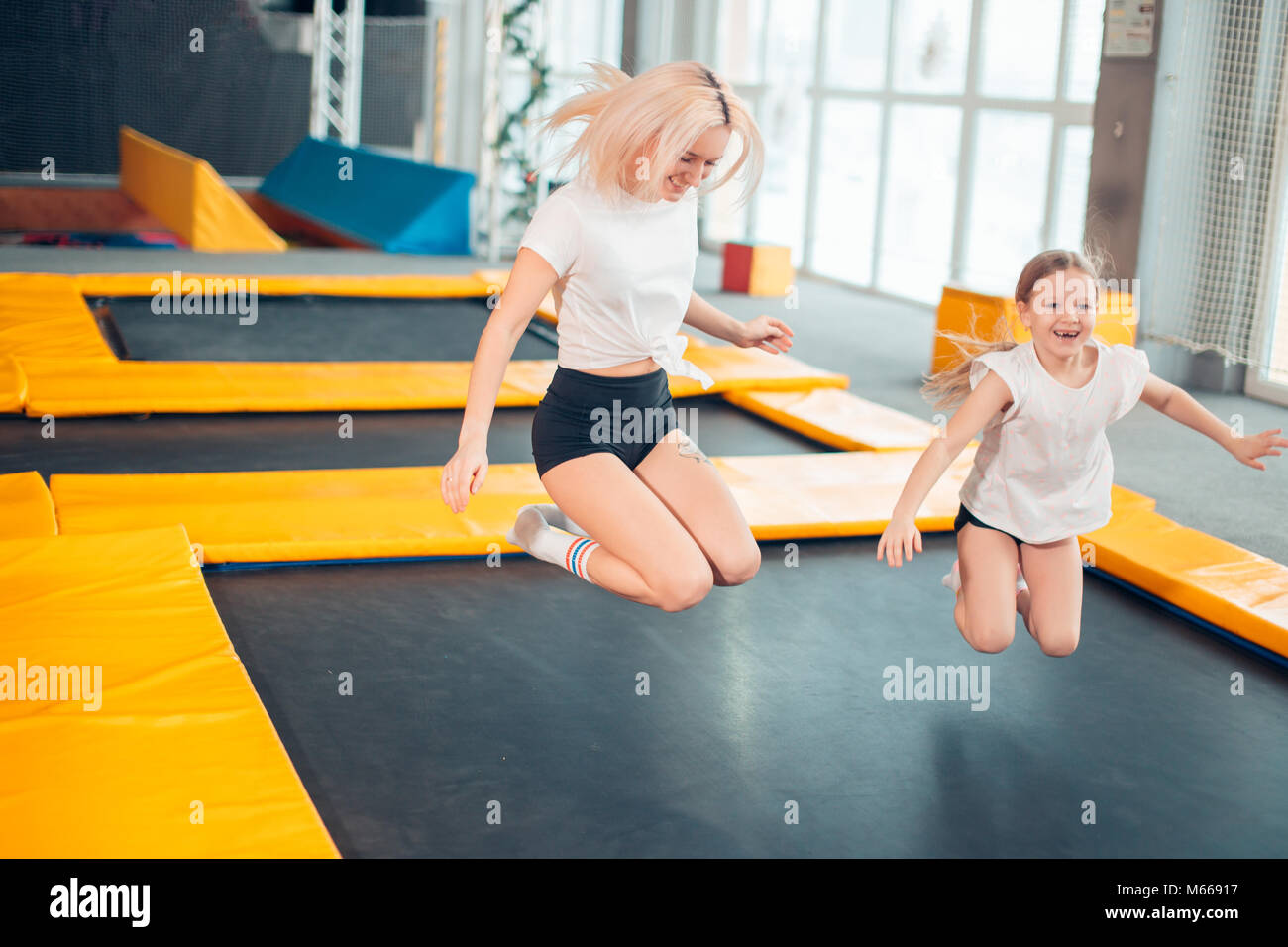 mother and daughter jumping on trampoline and doing split Stock Photo ...