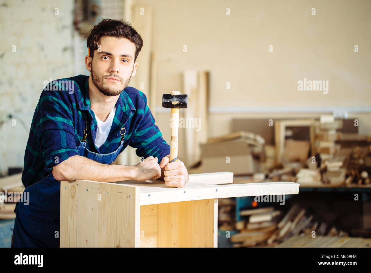 carpenter hammering a nail into wooden board Stock Photo - Alamy