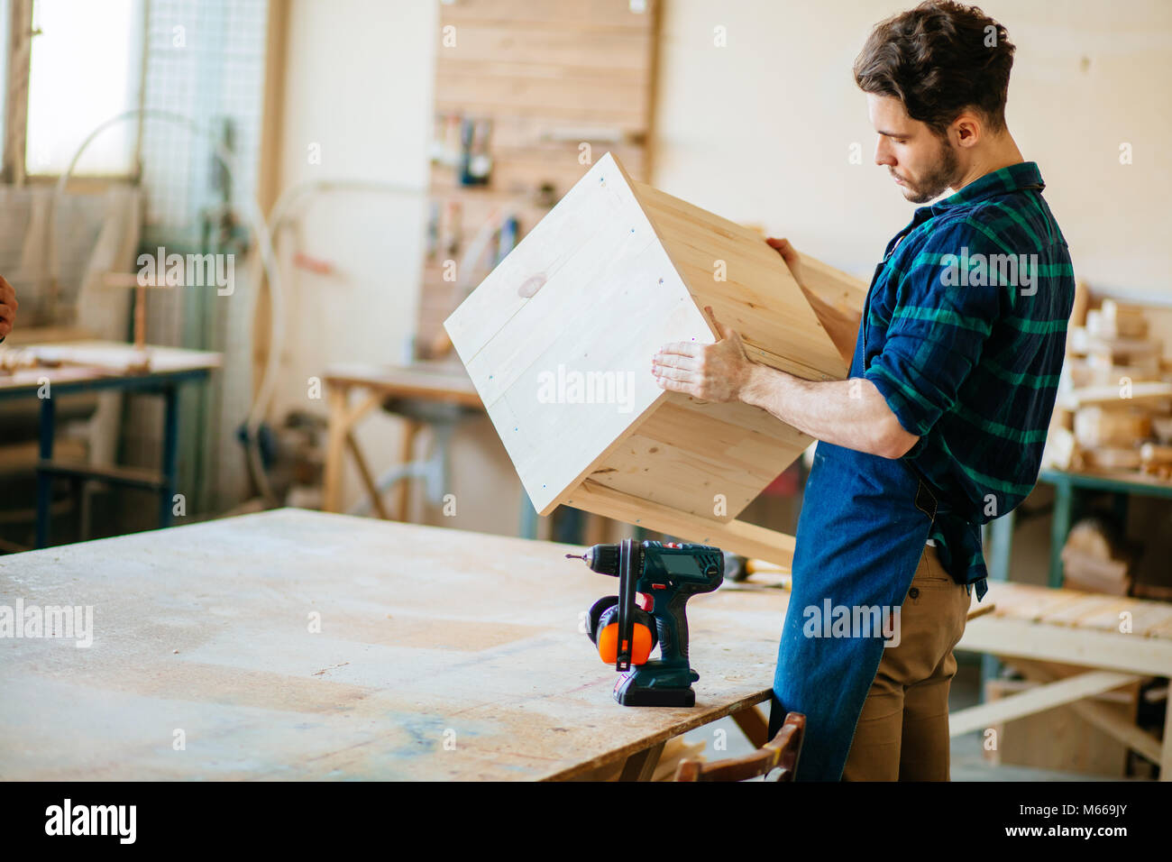 carpenter testing wood plank evenness at workshop Stock Photo - Alamy