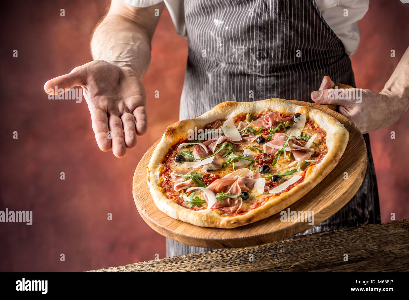 Chef and pizza. Chef offering pizza in hotel or restaurant Stock Photo ...