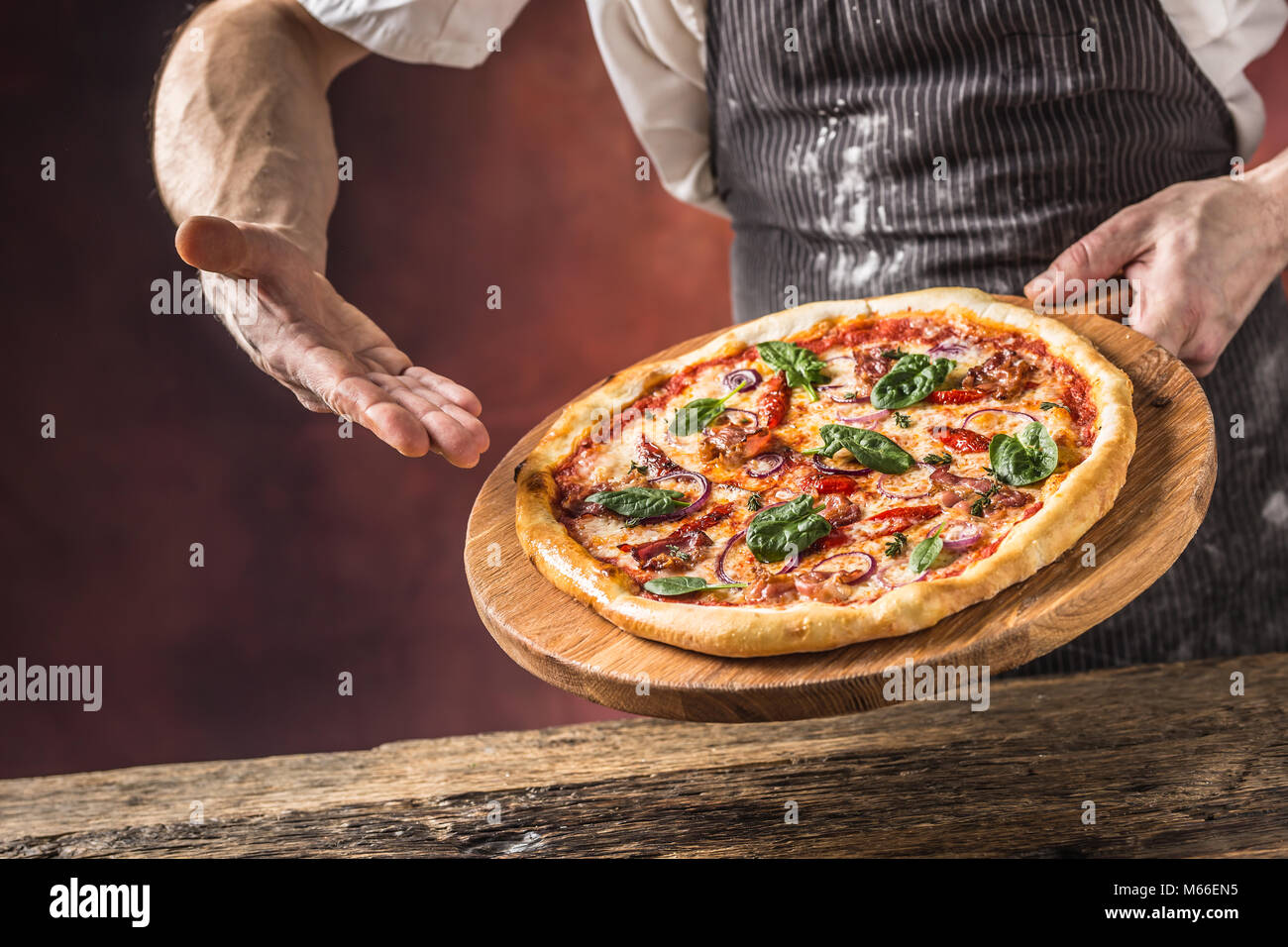Chef and pizza. Chef offering pizza in hotel or restaurant Stock Photo ...