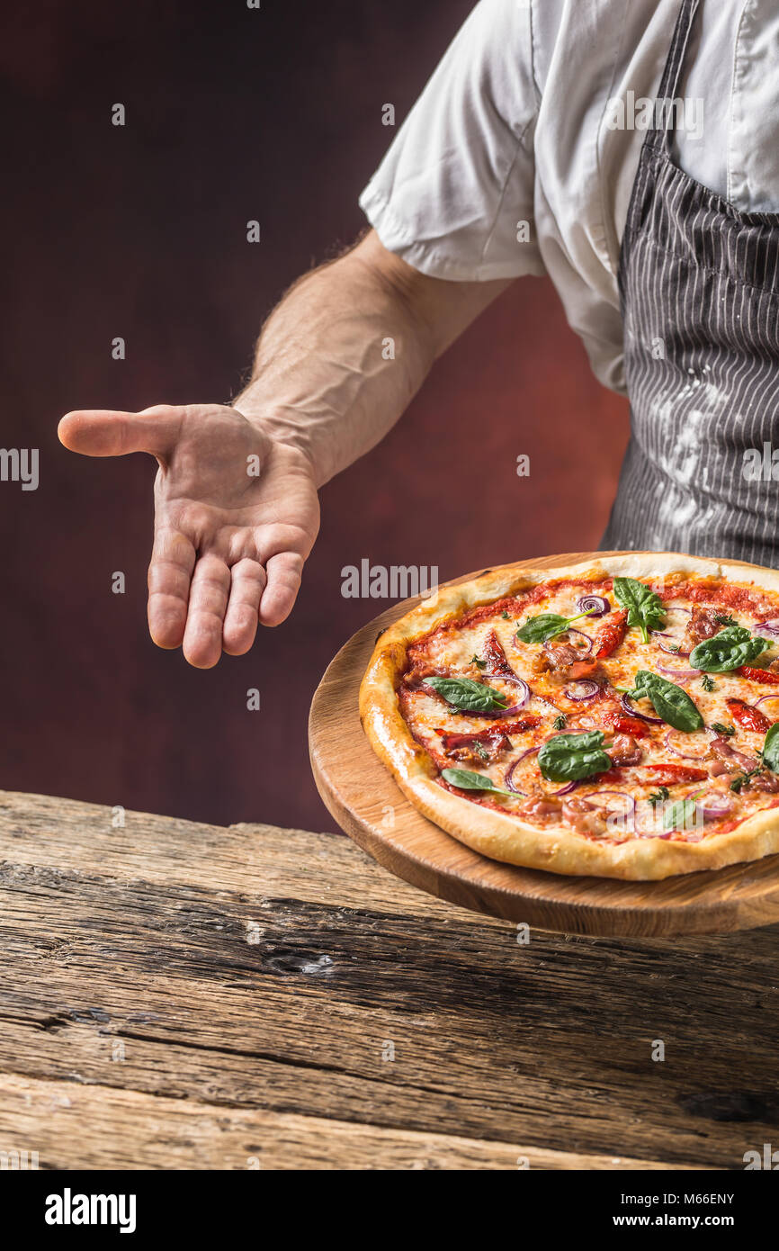 Chef and pizza. Chef offering pizza in hotel or restaurant Stock Photo ...