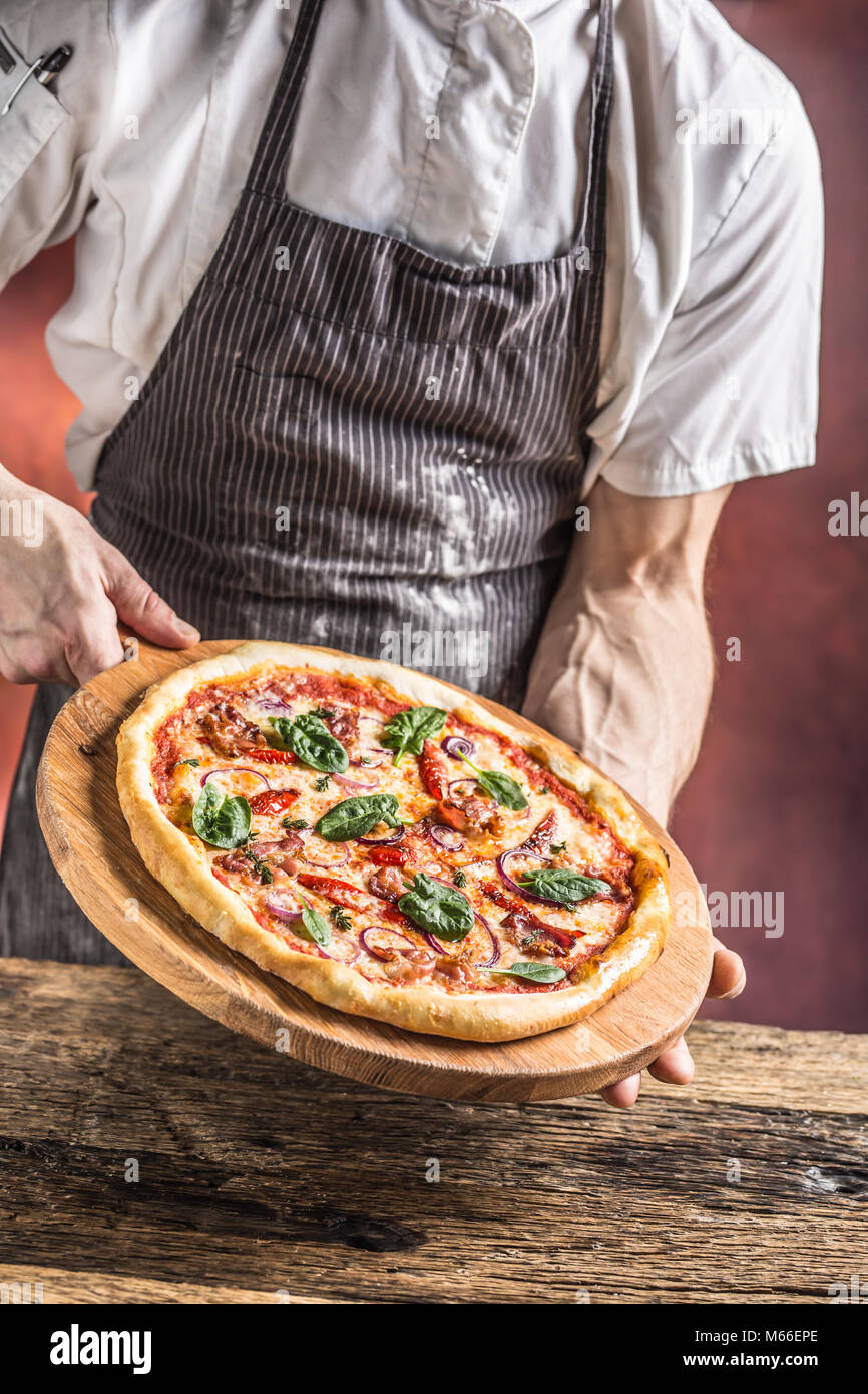 Chef and pizza. Chef offering pizza in hotel or restaurant Stock Photo ...
