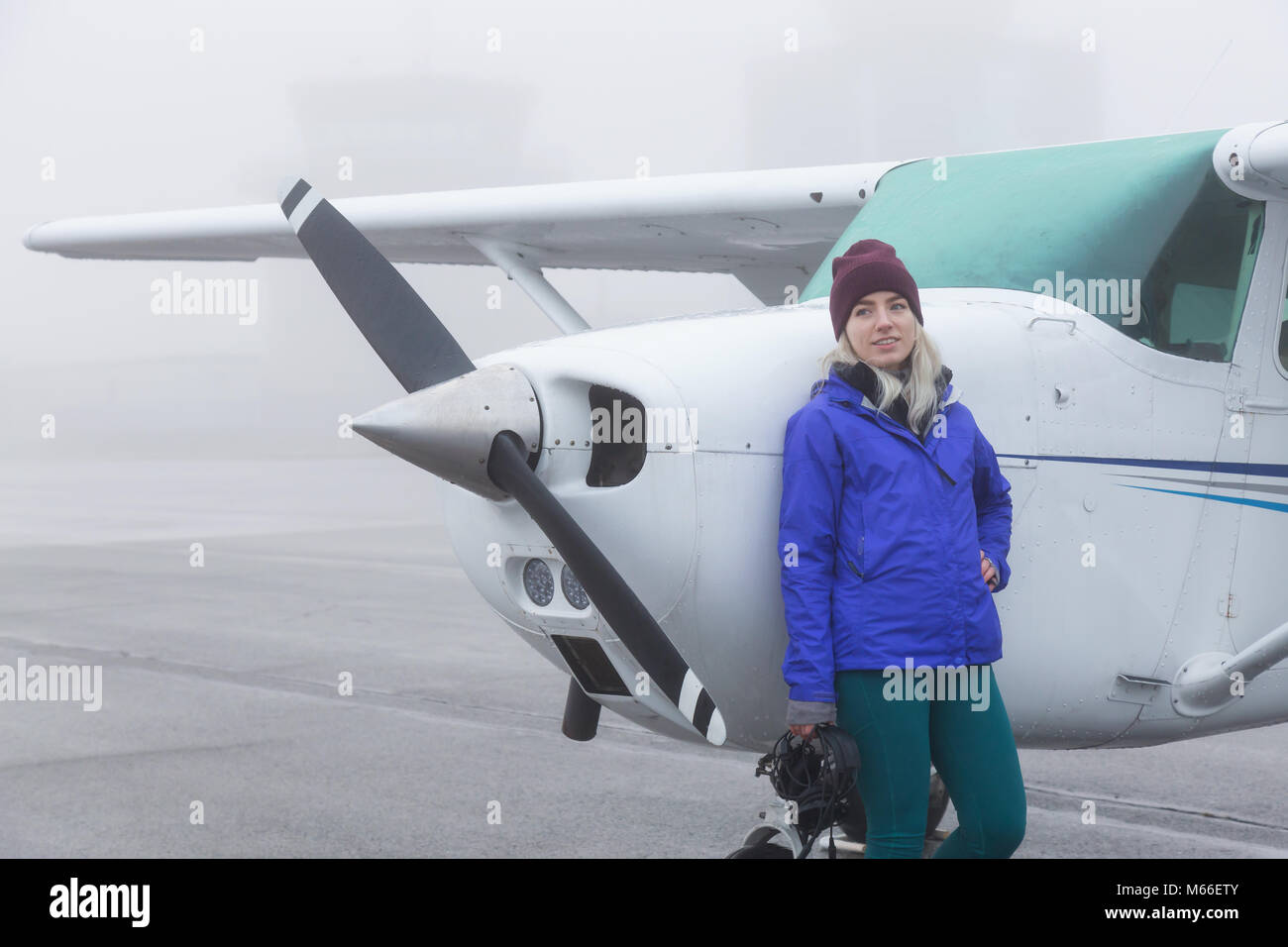Young Caucasian Female Student Pilot is standing in front of a Single ...