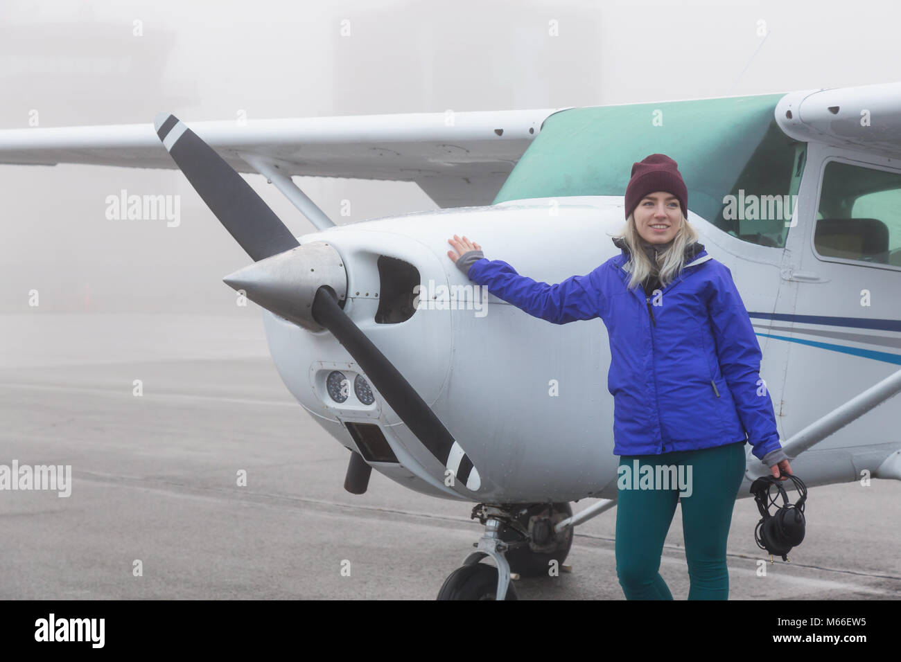 Young Caucasian Female Student Pilot is standing in front of a Single ...