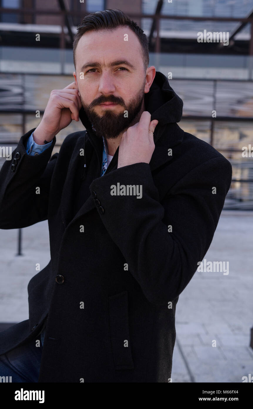 Man pulling up the collar on his coat Stock Photo - Alamy