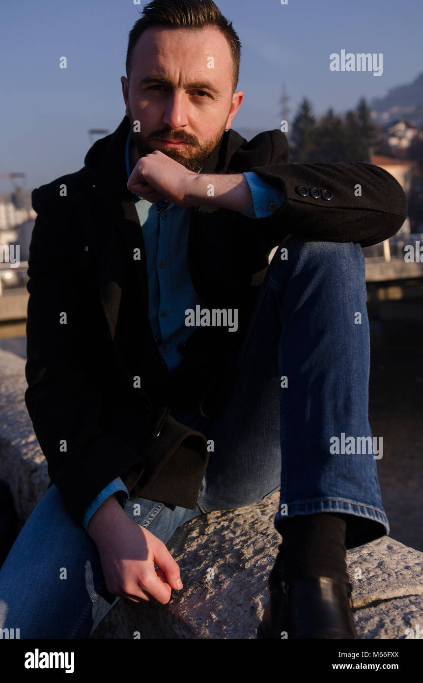 Man sitting on a wall Stock Photo - Alamy