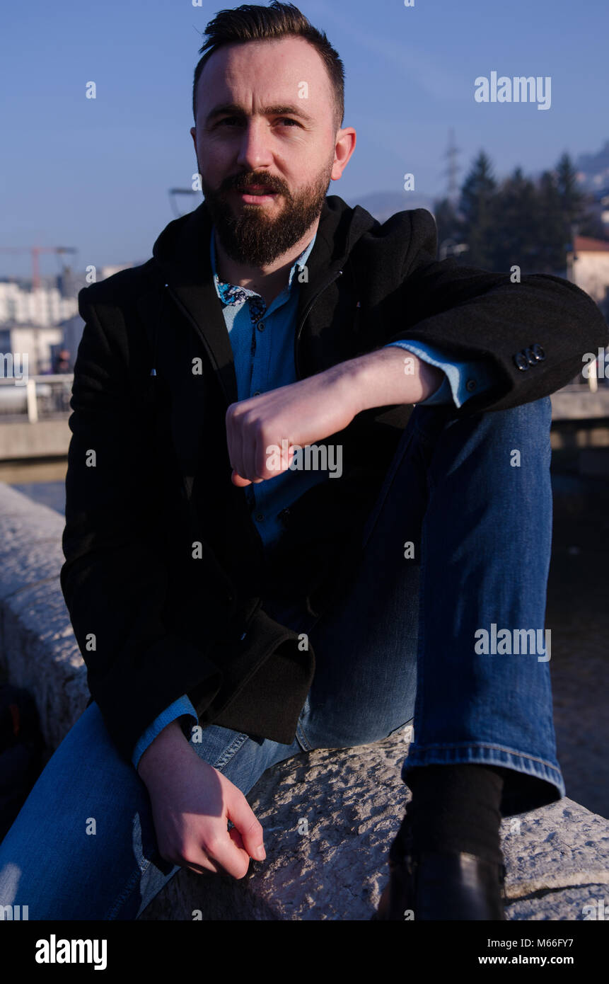 Man sitting on a wall Stock Photo - Alamy