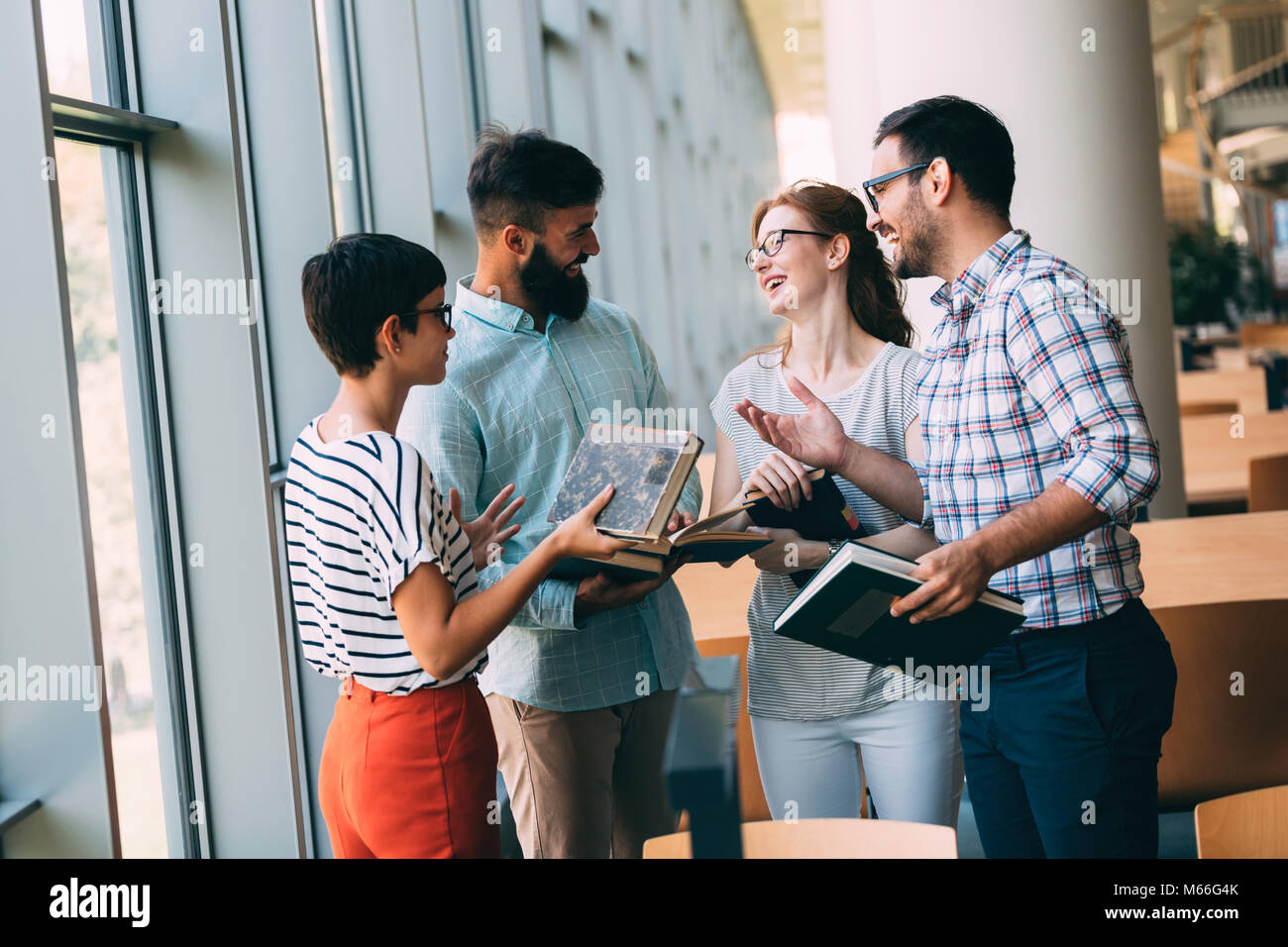 Group of students discussing in university library Stock Photo - Alamy