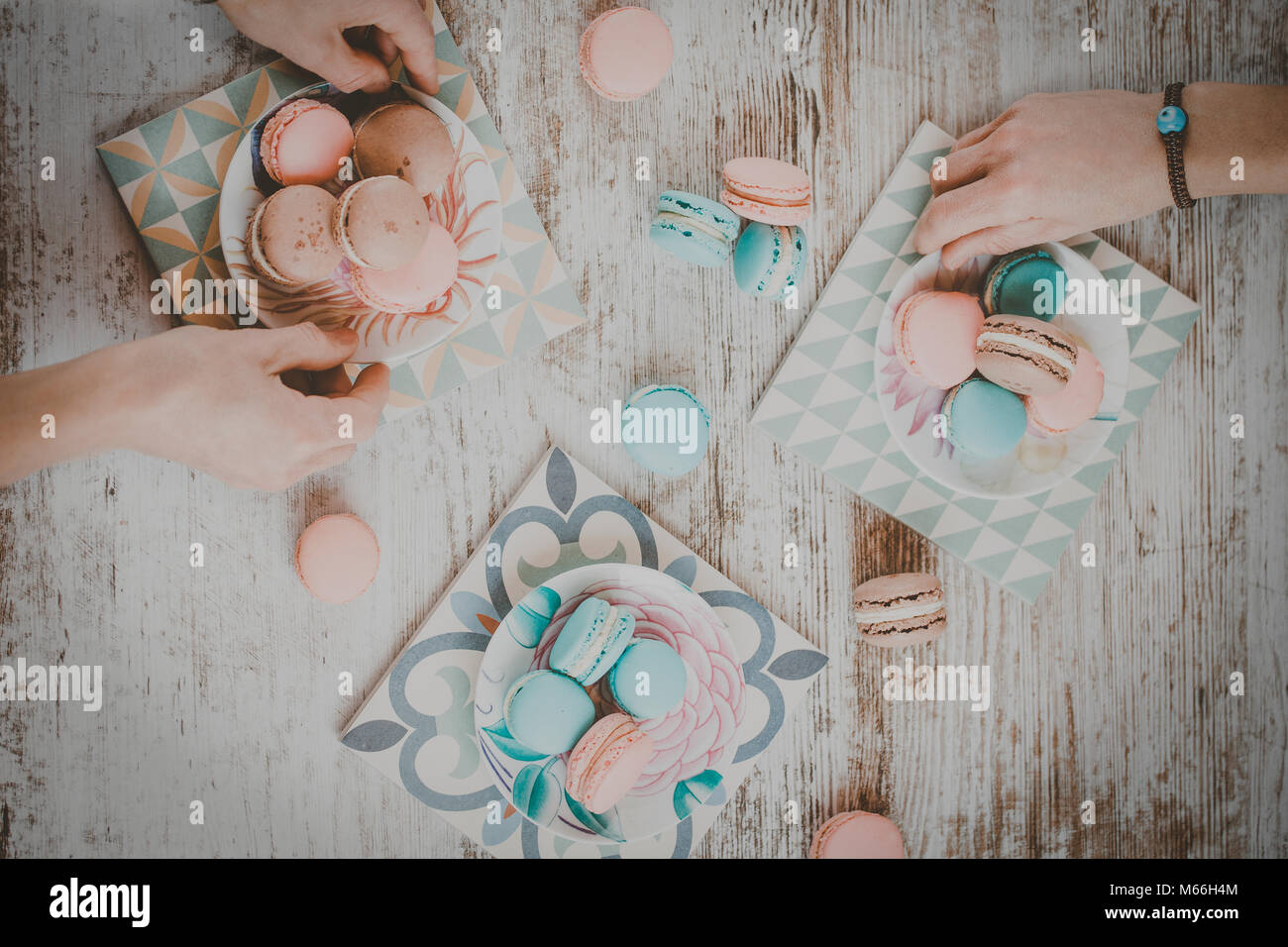 Two women eating macaroons Stock Photo - Alamy
