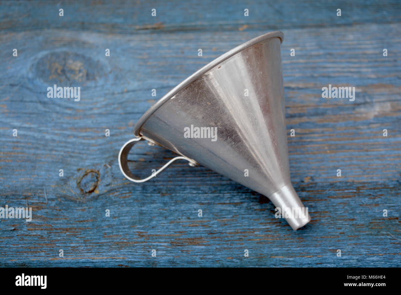 Vintage metal funnel with handle on old wooden garden table background ...