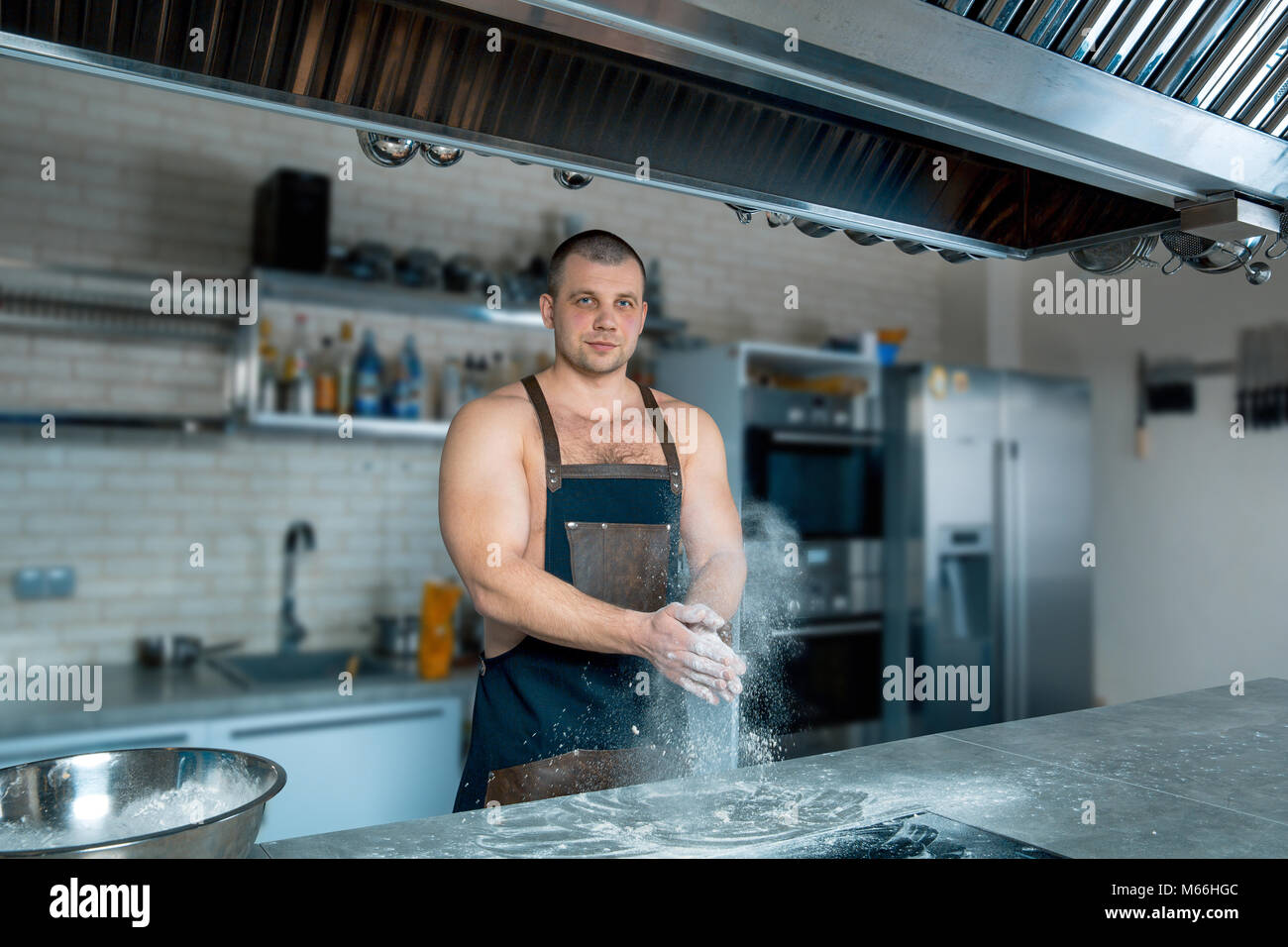 chef Cook bodybuilder claps his hands with flour on the kitchen ...