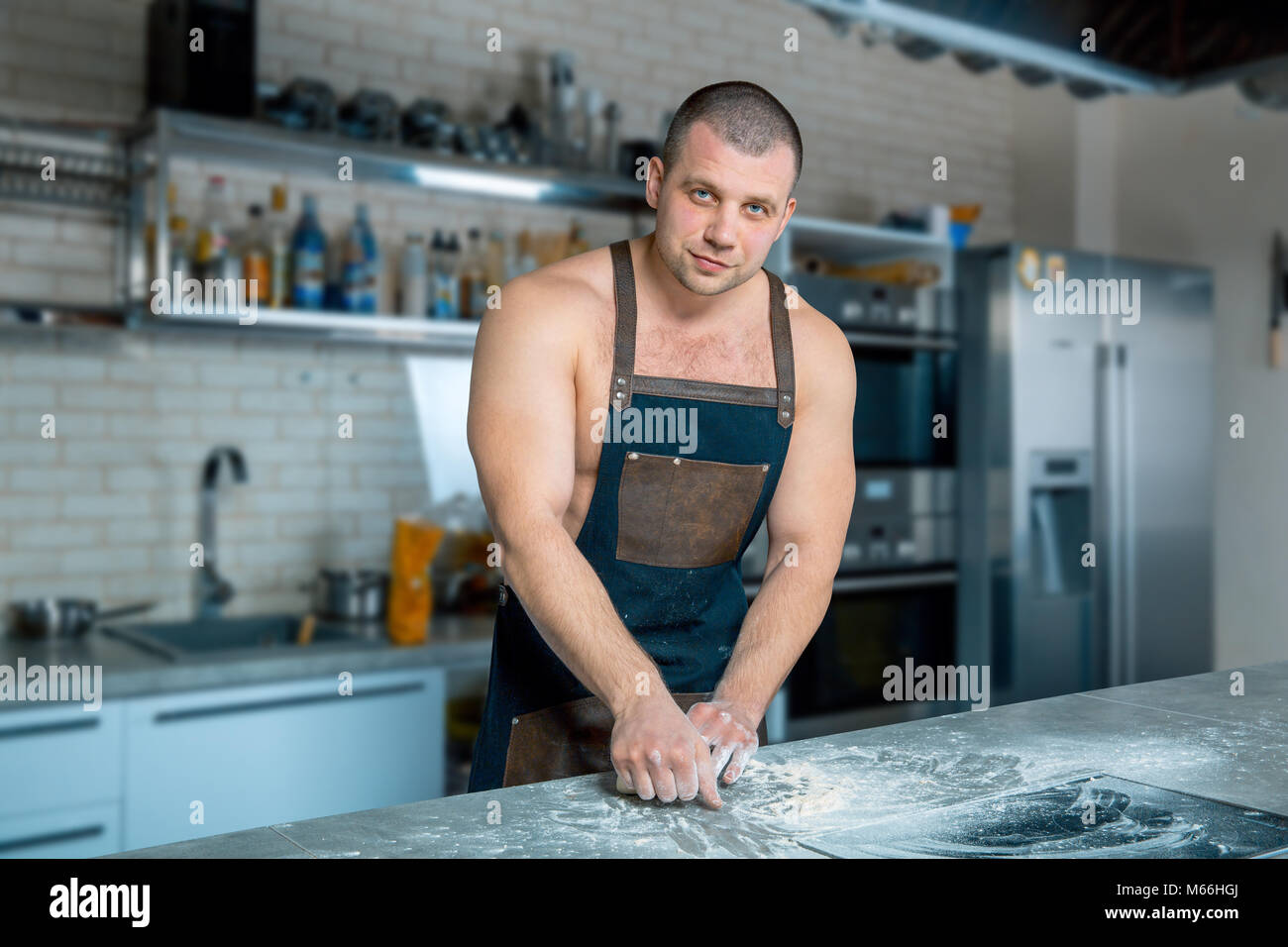 bodybuilder chef in hotel or restaurant kitchen interior knead the ...