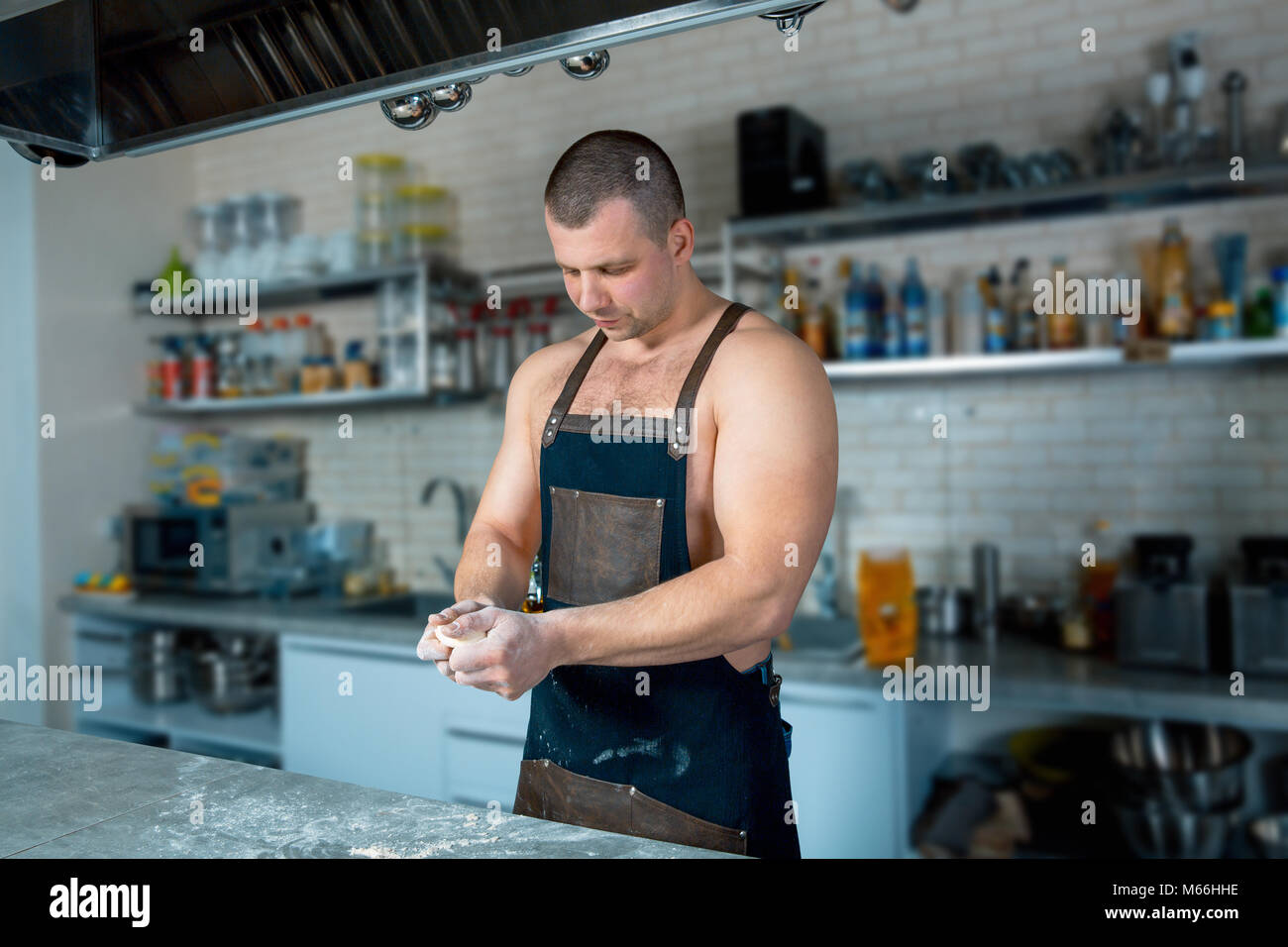bodybuilder chef in hotel or restaurant kitchen interior knead the ...