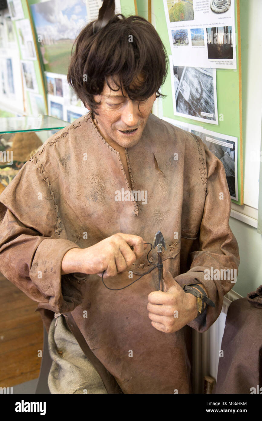 Mannequin model of male Mesolithic hunter attaching flint arrow head ...