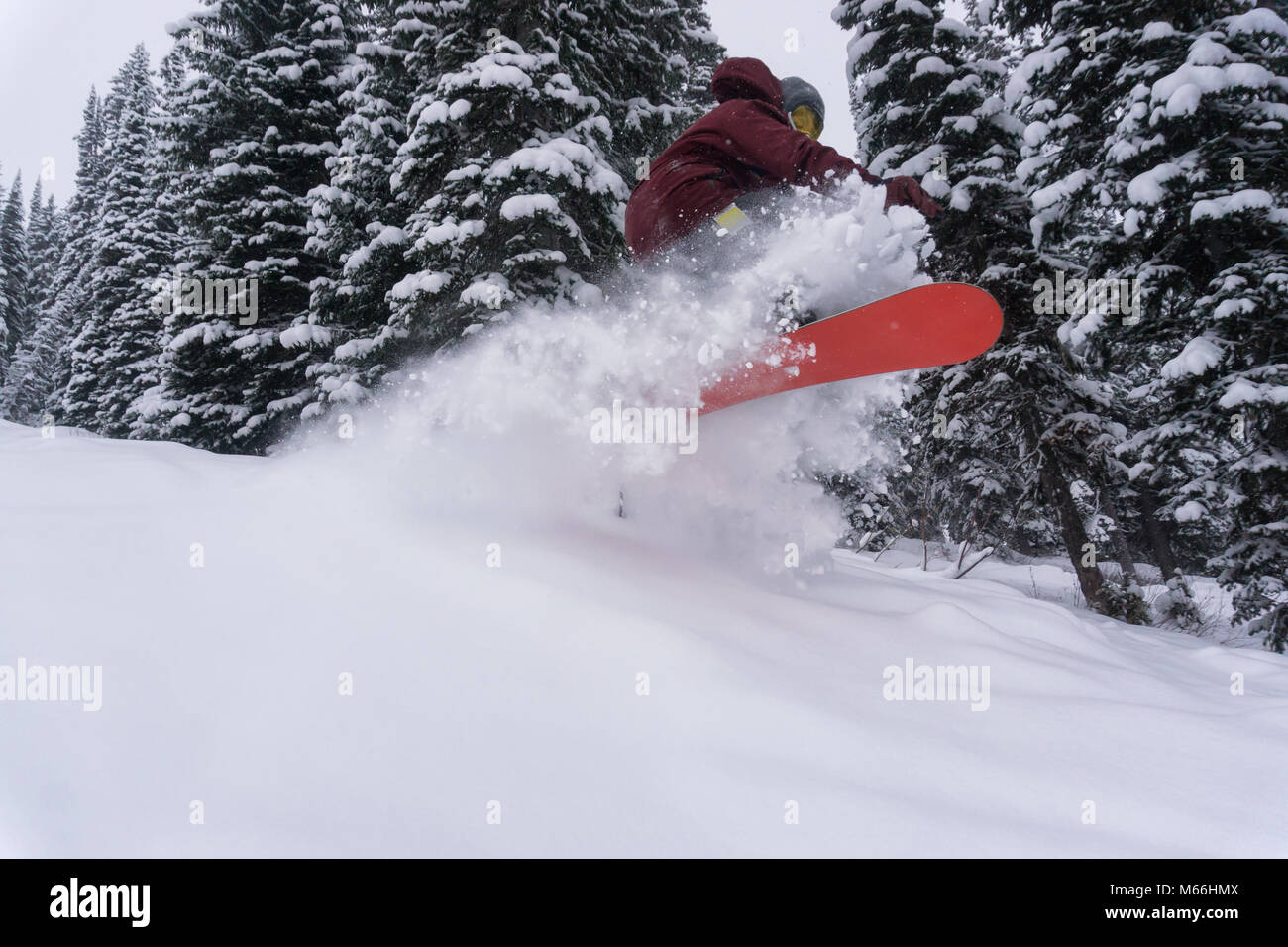 Male snowboarder riding white powder snow in the extreme terrain. Taken ...