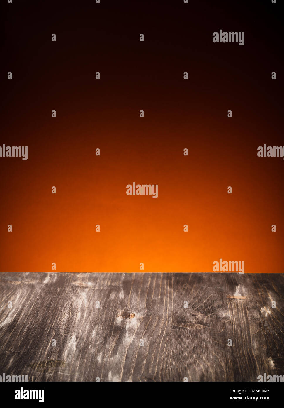Orange background and wooden table Stock Photo - Alamy