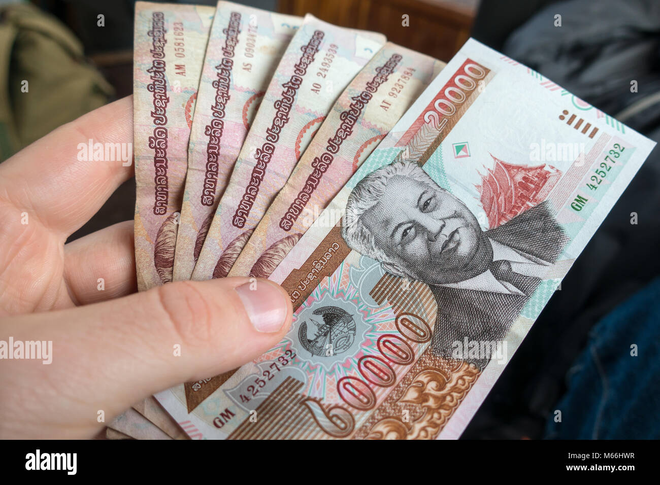 Mans hand holding Laos money, kip banknotes close up Stock Photo - Alamy