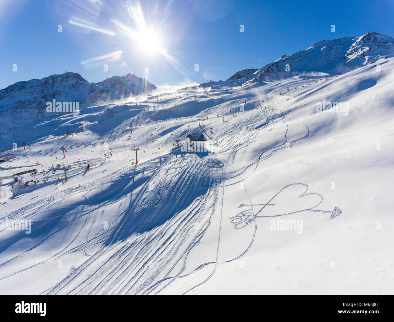 Love to ski. Aerial image of a ski slope in the Alps. Lens flare ...