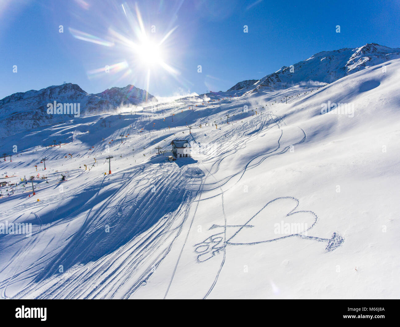Love to ski. Aerial image of a ski slope in the Alps. Lens flare ...