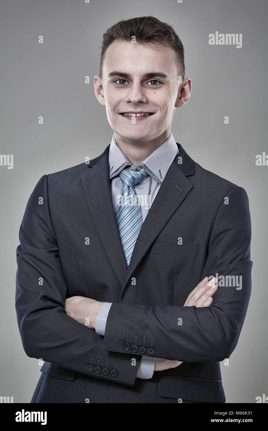 Young man in classic business suit with arms folded Stock Photo - Alamy
