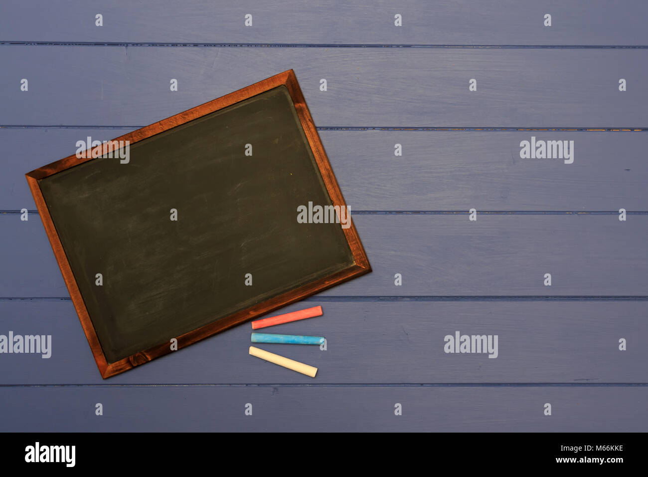 Slate chalk board with coloured chalk sticks on shabby blue board ...
