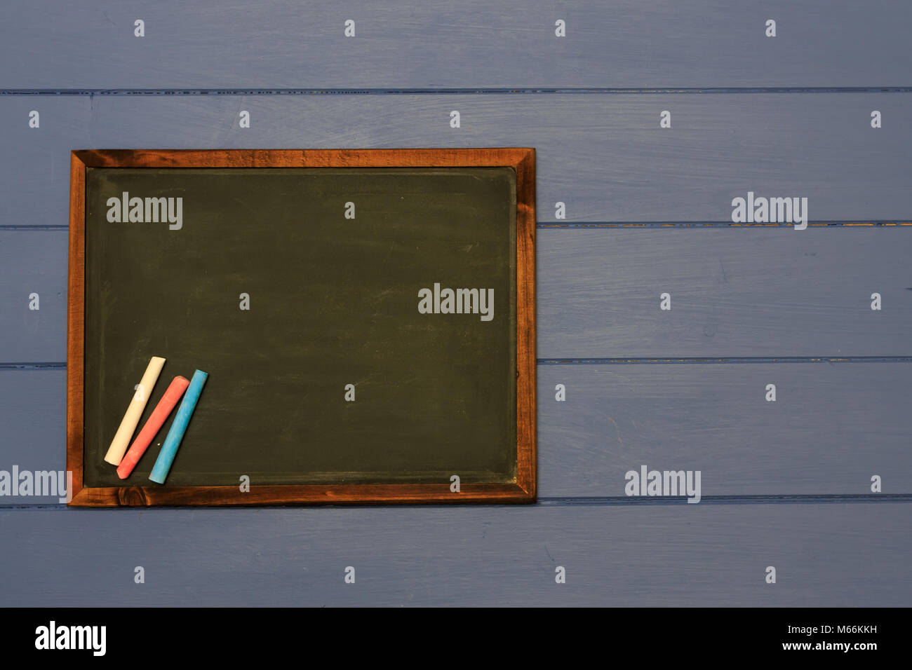 Slate chalk board with coloured chalk sticks on shabby blue board ...