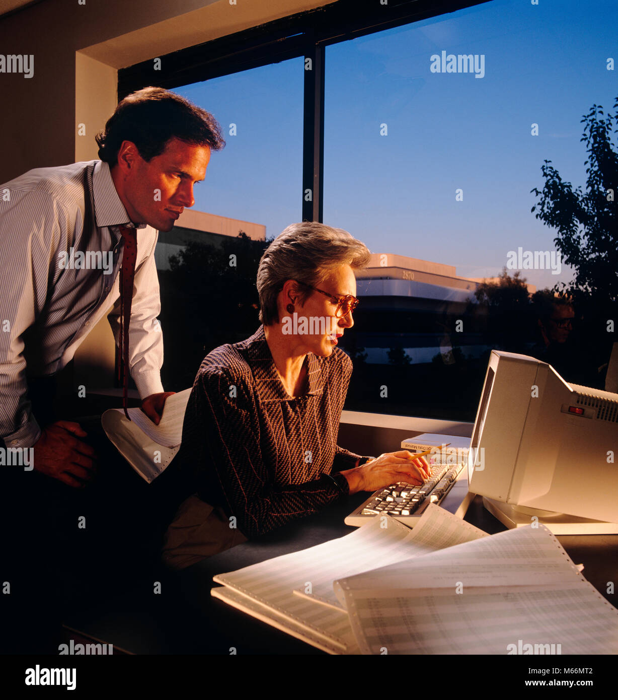 1980s 1990s MAN AND WOMAN WORKING WITH COMPUTER AT NIGHT - ko3143 ...